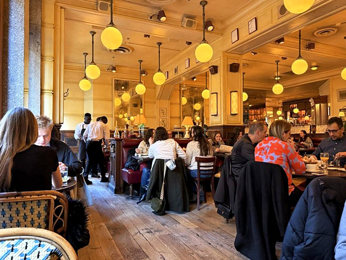 The warm glow of pendant lights transforms ordinary diners into characters in a delicious French film. Everyone looks better in this lighting&mdash;even the food.