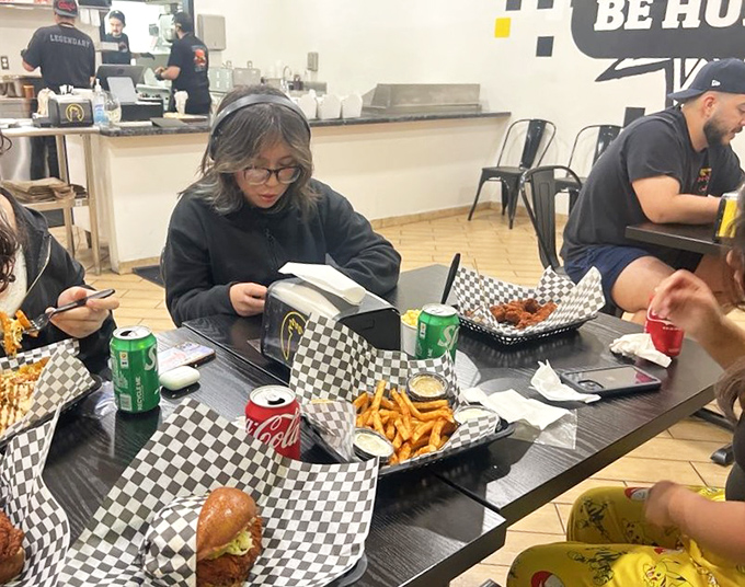The universal language of good food: strangers united by crispy chicken, crinkle fries, and the silent nod of "this was worth it."