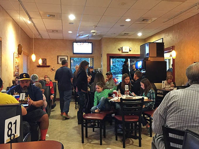 A bustling dining room where strangers become temporary family, united by their shared devotion to Pittsburgh's most unconventional pizza.