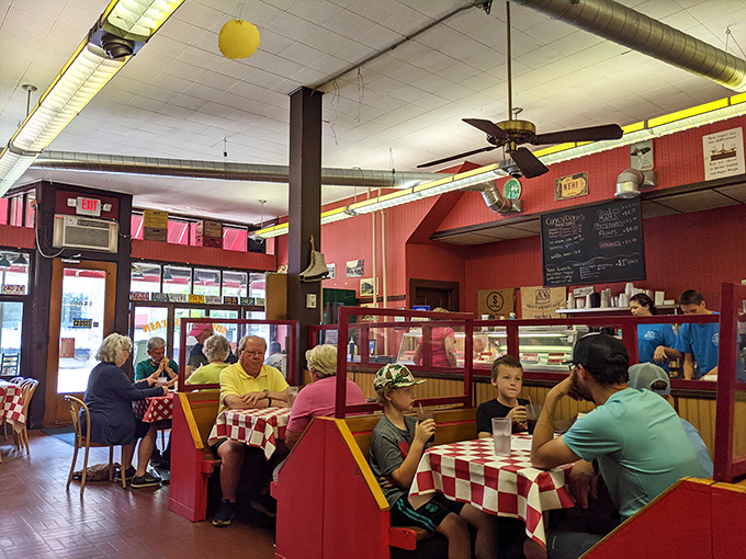 Three generations sharing one table, all temporarily forgetting their phones exist. The real social network happens over shared fries.