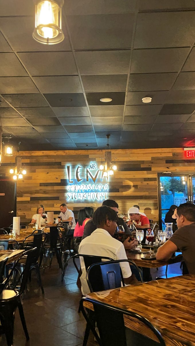 The neon sign glows like a beacon for the hungry, while diners below are already deep in that universal language of food appreciation. 