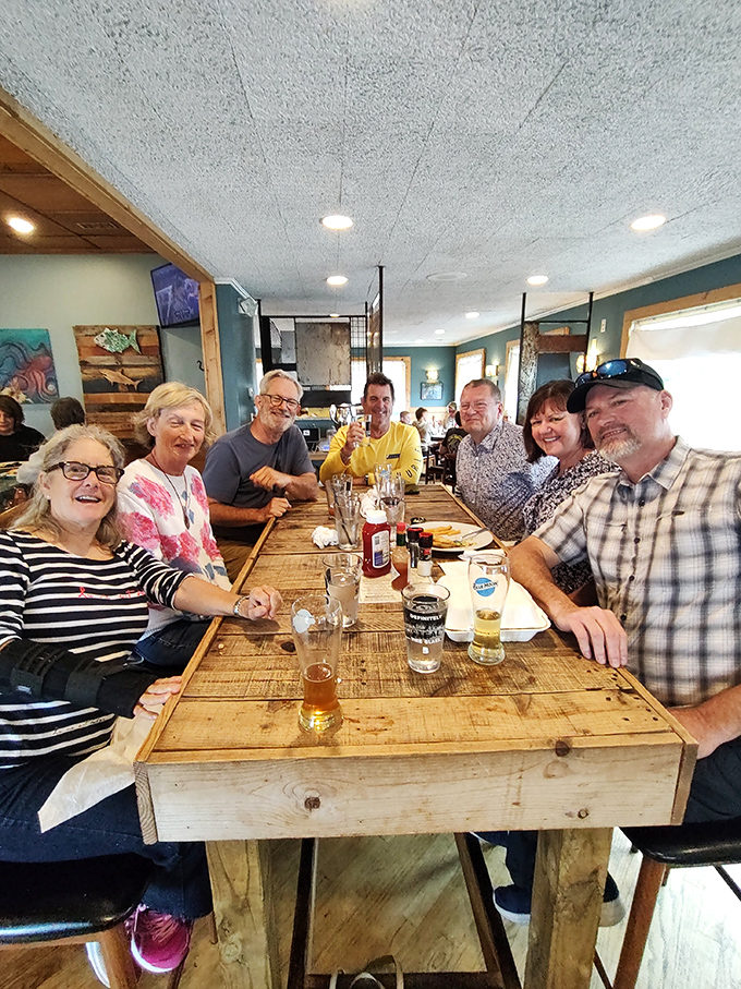 Happy diners gathered around rustic wooden tables&mdash;proof that great food creates instant community. These folks aren't just eating; they're making memories.