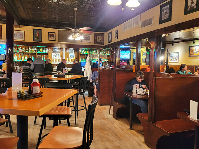 The bar area where strangers become friends and friends become regulars. Those wooden booths have absorbed decades of laughter and stories.