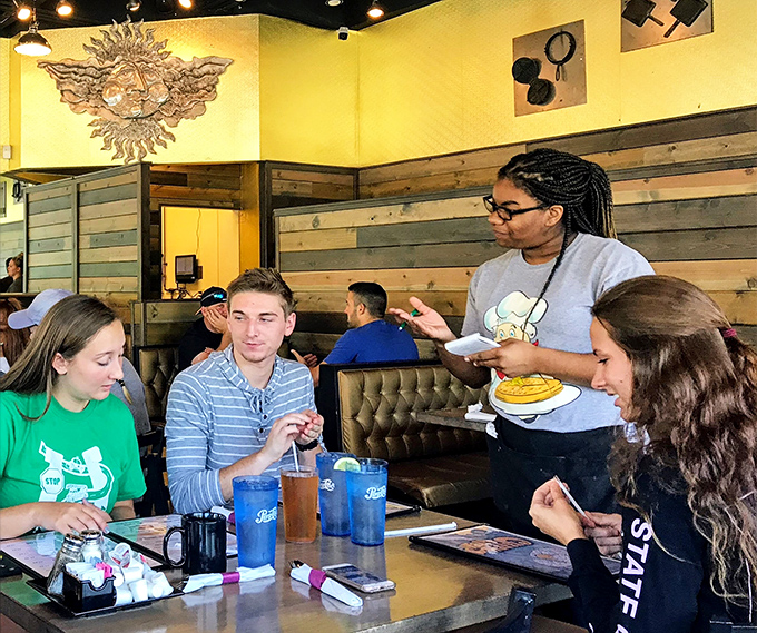 The universal language of good food being spoken as servers deliver plates of joy to eager breakfast enthusiasts.