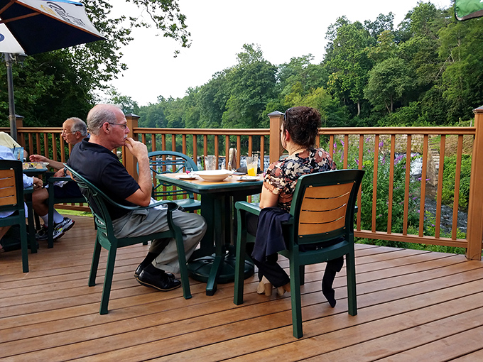 Outdoor dining with a creek view &ndash; because food tastes better when birds might steal your fries.