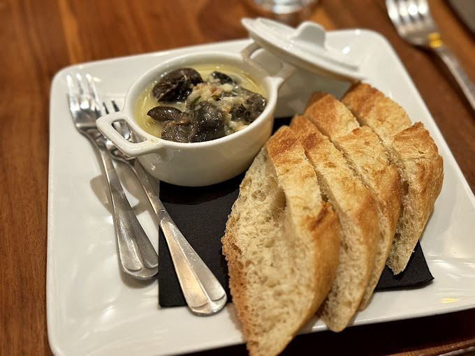 Escargot: where culinary courage meets buttery bliss. These little guys swimming in garlic-herb butter might just convert even the most skeptical skeptics.
