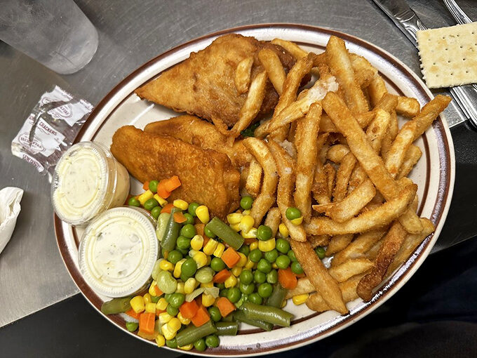 Fish and chips with a side of mixed vegetables—because balance is important when you're about to consume this much delicious fried goodness.