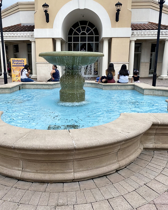The fountain creates an oasis of tranquility amid retail chaos—a gathering spot where tired shoppers rest while children make wishes with spare change.