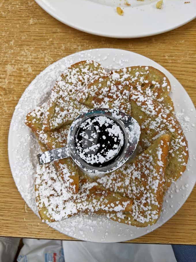 French toast dusted with powdered sugar like the first perfect snowfall of winter. That little cup of syrup is about to make magic happen.