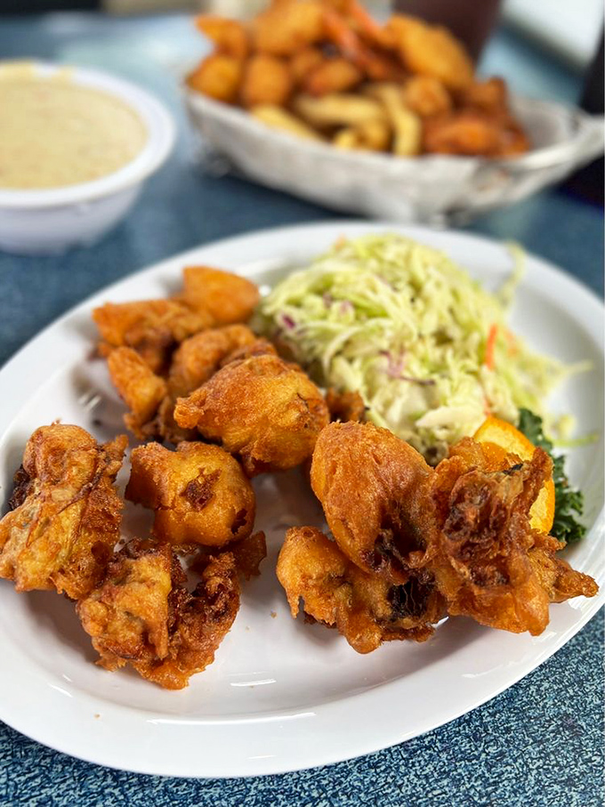 Onion rings stacked like the seafood version of the Leaning Tower of Pisa. Architectural deep-fried masterpieces that demand to be photographed.