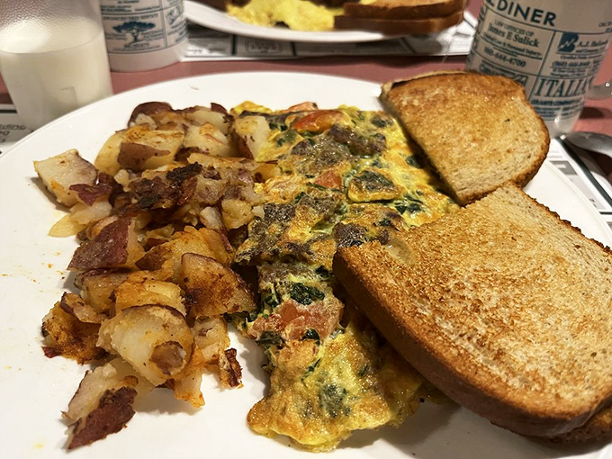 This omelet has clearly been to the gym—packed with veggies and perfectly browned. Those home fries and toast are the loyal sidekicks every hero needs.