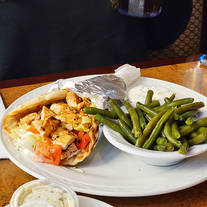 A gyro wrapped so perfectly it could teach master gift-wrappers a thing or two. Those green beans on the side are fooling exactly no one.