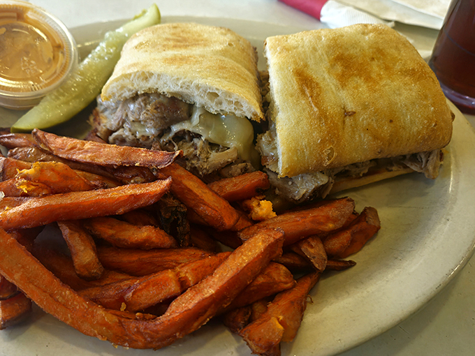 This sandwich isn't messing around – substantial enough to require jaw exercises before attempting, with sweet potato fries that deserve their own fan club.