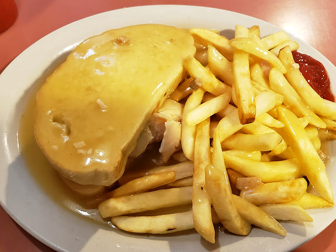 Hot turkey sandwich swimming in gravy represents comfort food at its most honest, accompanied by fries that understand their supporting role.