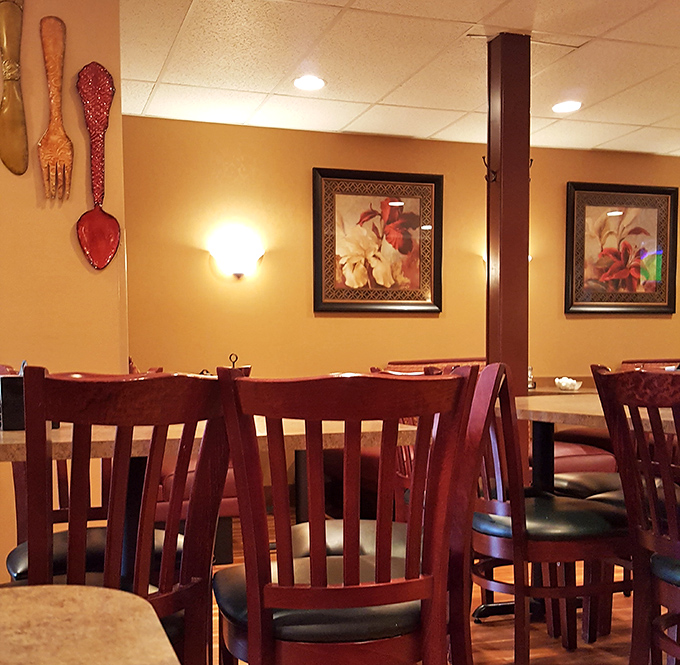 Decorative spoons and forks watch over diners like culinary guardian angels. The warm wood tones practically hug you while you eat.