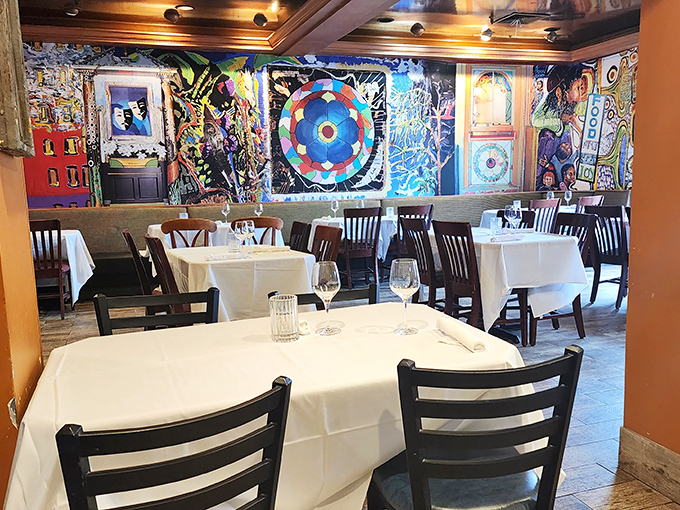 White tablecloths against vibrant artistic walls create that rare balance of fine dining comfort without a hint of pretension.