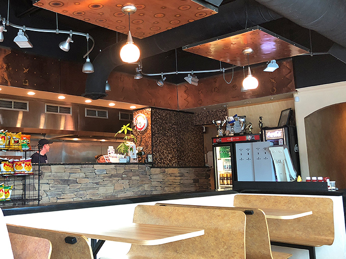 Modern stone accents and warm lighting create the perfect backdrop for serious pizza appreciation and casual conversation.