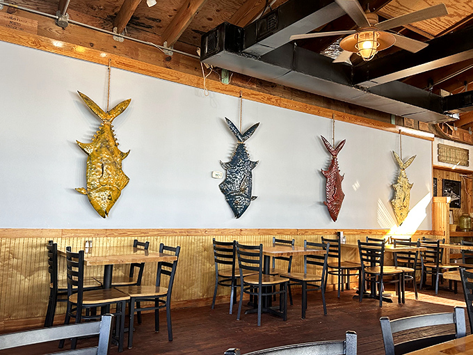 Metallic fish sculptures swim eternally across white walls – artistic trophies that celebrate the ocean's bounty without a hint of taxidermy.