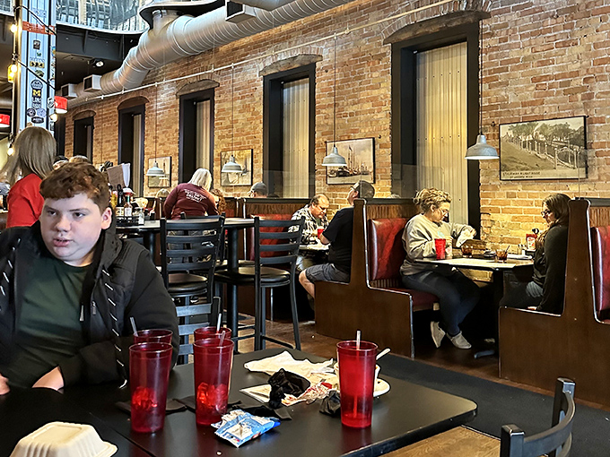 The warm glow of pendant lights illuminates conversations worth having. Red booths invite you to settle in and stay awhile.