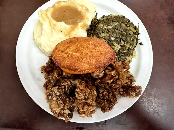 A classic Southern meat-and-three featuring mashed potatoes with gravy, collard greens, and a cornbread muffin&mdash;comfort food that speaks a universal language.