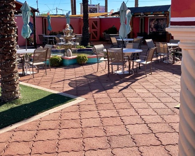 A fountain creates the soundtrack for this peaceful courtyard dining space. The pink walls aren't just a color choice&mdash;they're a mood-enhancing design decision.