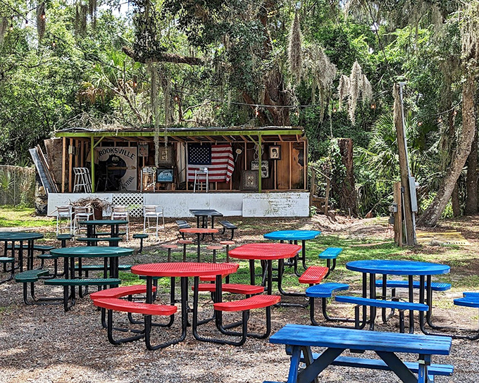 Colorful picnic tables under Spanish moss create an outdoor dining room where hot dogs taste even better with a side of fresh air.