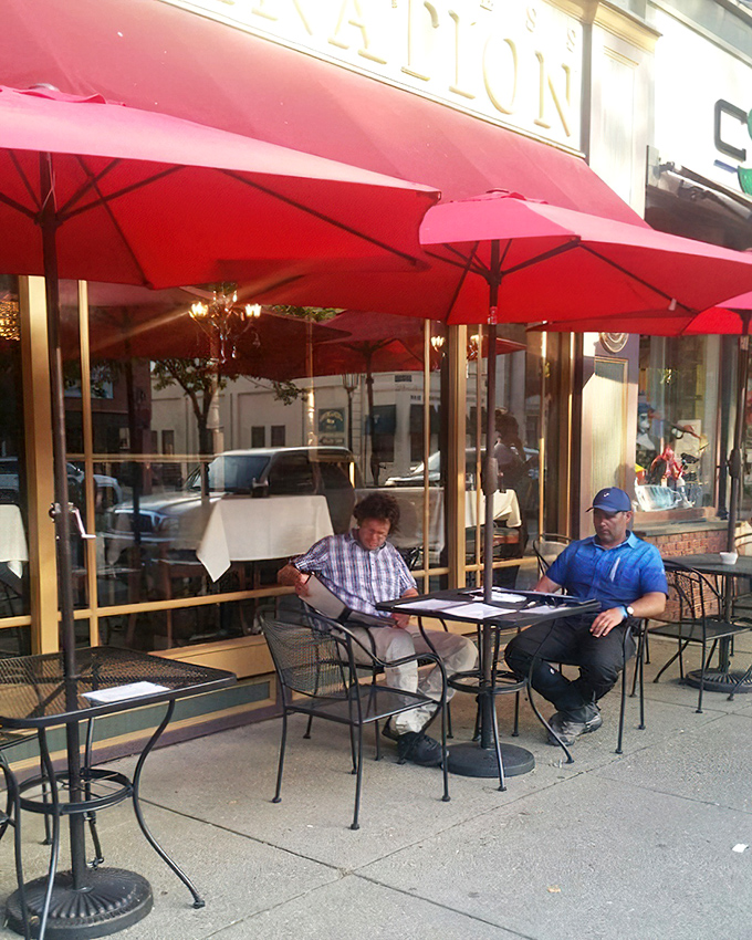 Sidewalk dining under cheerful red umbrellas—where menus are studied with the concentration of scholars and decisions are deliciously consequential.