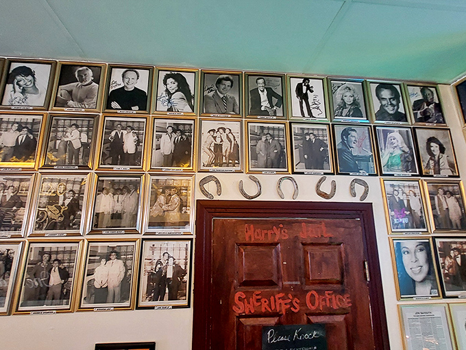 A wall of fame where celebrity photos watch over diners like barbecue guardian angels, silently approving your order choices.