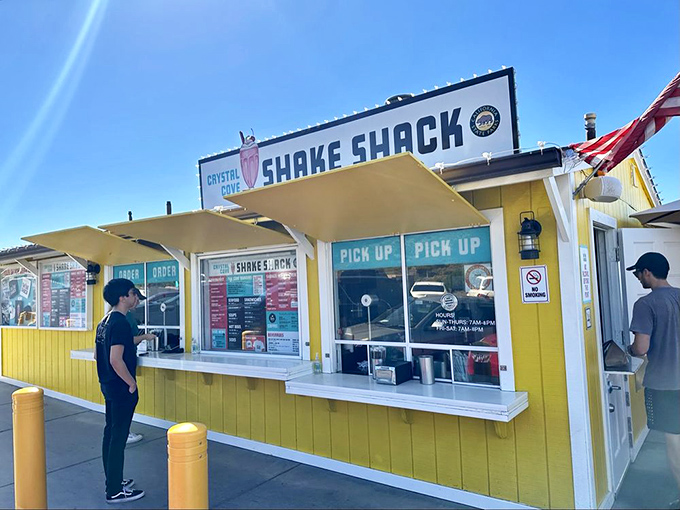 The cheerful yellow ordering windows welcome hungry visitors like old friends, with "PICK UP" signs guiding you to imminent satisfaction.