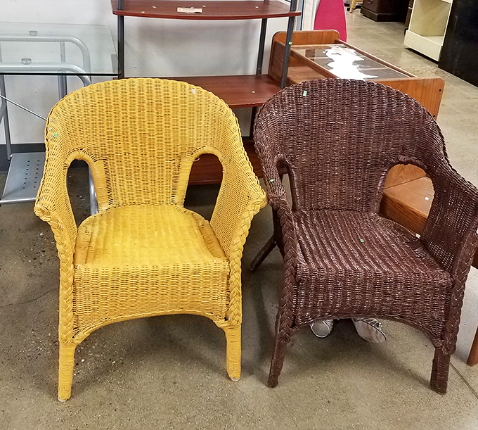 The wicker chair twins &ndash; one sunshine yellow, one chocolate brown &ndash; waiting for someone to give them the porch life they deserve.