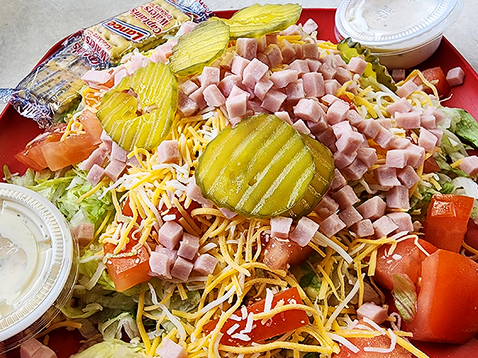This isn't just a salad&mdash;it's a celebration of abundance. Pickles standing guard over a mountain of ham, cheese, and fresh vegetables.