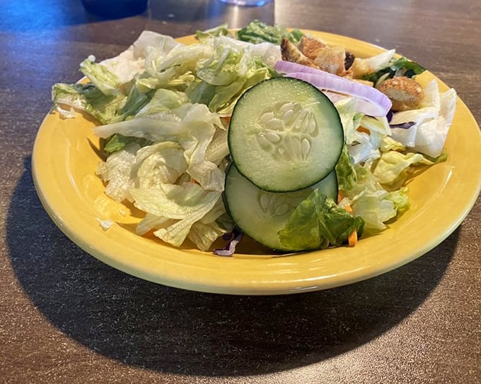 Even the side salad gets respect here&mdash;crisp, fresh, and vibrant on a sunny yellow plate that brightens the whole table.
