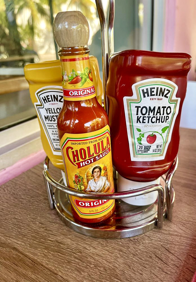 The condiment caddy&mdash;where Cholula, ketchup, and mustard form the holy trinity of flavor enhancement for whatever massive plate arrives next.