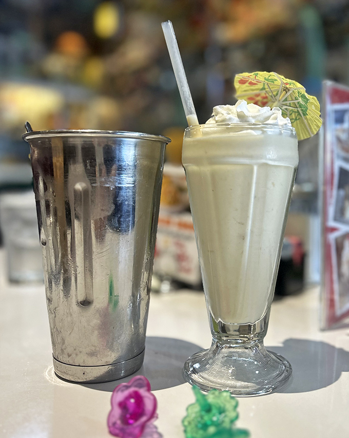 A proper milkshake served with the mixing tin&mdash;because one glass is never enough. That tiny umbrella isn't decoration, it's optimism.