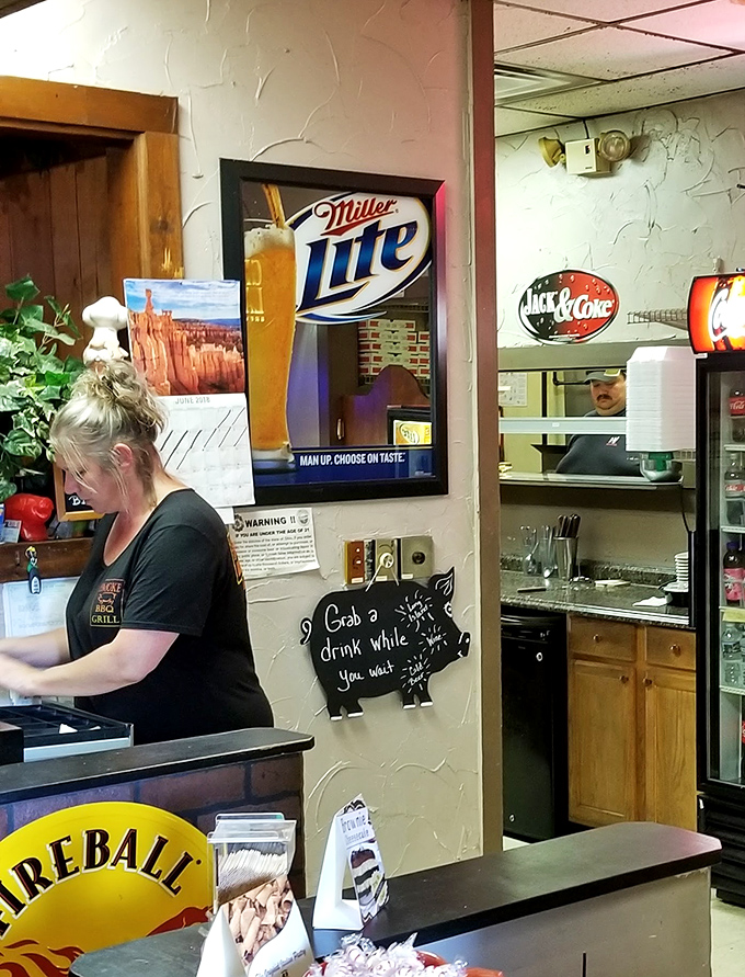 A sign that perfectly captures the BBQ joint's philosophy: grab a drink and settle in. Good things come to those who wait for slow-smoked perfection.