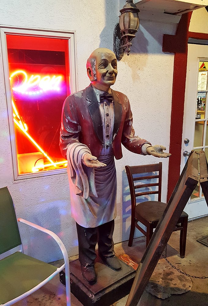 The silent ma&icirc;tre d' who never judges your order. This vintage waiter statue has seen thousands of pizza lovers come and go through these doors.