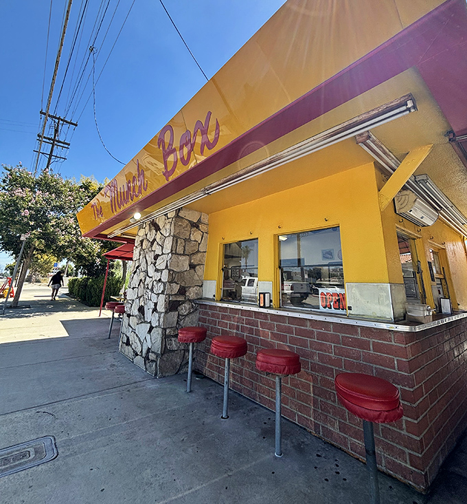 The stone-and-brick exterior with classic counter stools invites you to pull up, place your order, and become part of a decades-long California tradition.