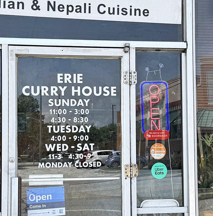 The hours posted clearly on the door &ndash; essential information for planning your curry pilgrimage to this Erie landmark.