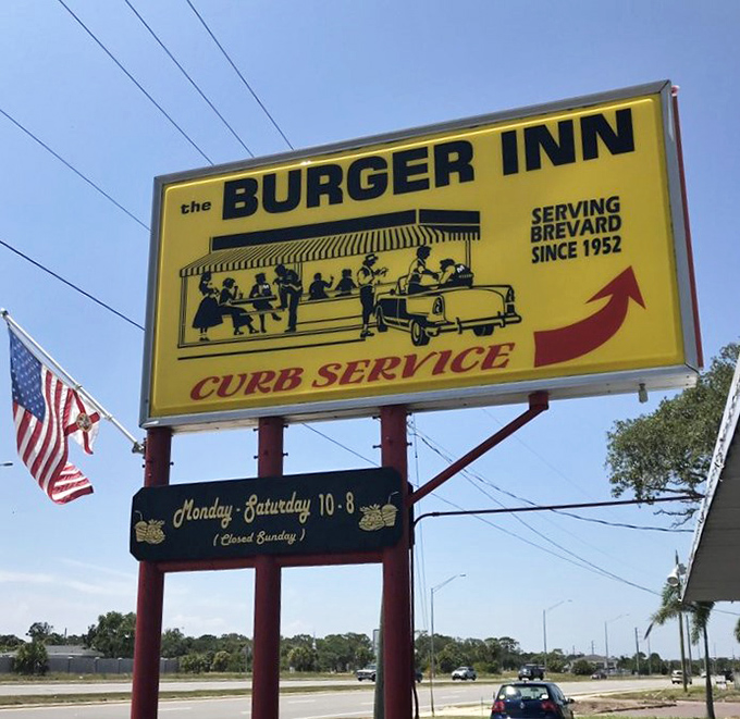 The sign promises curb service and delivers on nostalgia. In a world of digital menus and QR codes, this yellow beacon stands gloriously analog.