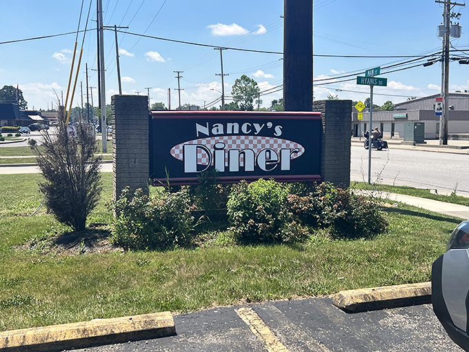 The roadside sign beckons hungry travelers with its classic diner logo &ndash; a beacon of hope for those seeking refuge from chain restaurant monotony.