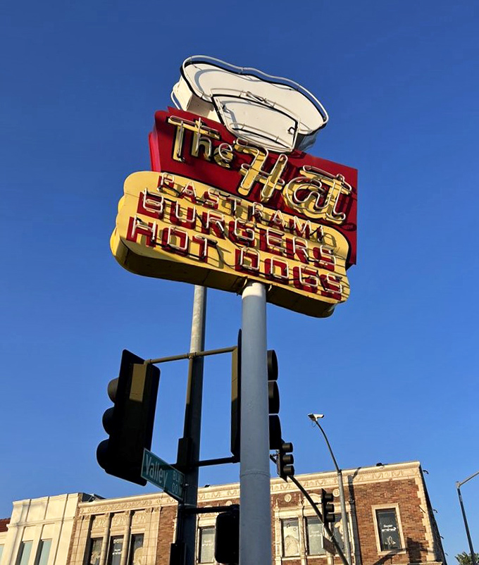 The Hat's vintage neon sign doesn't just advertise&mdash;it announces with mid-century flair that pastrami paradise awaits below.