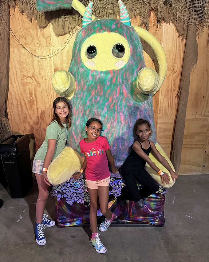 The friendliest monster you'll ever meet, with children posing as proof that even otherworldly creatures love photo ops.