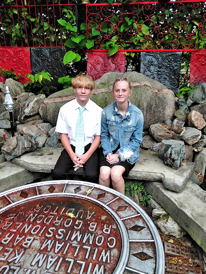 Young visitors find a moment of peace on a stone bench. The Temple welcomes all generations to its contemplative spaces.