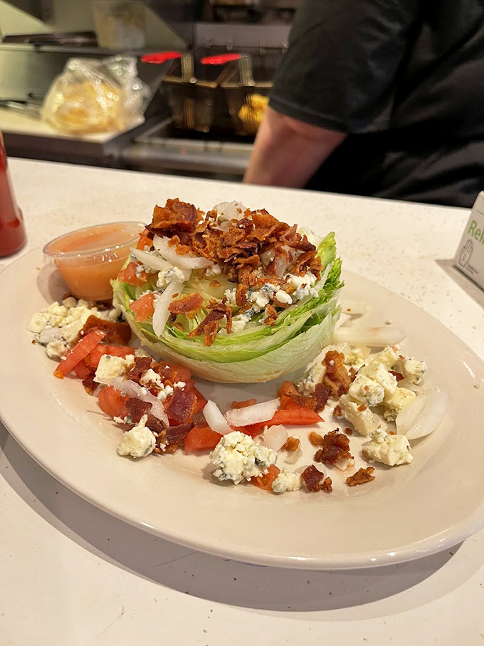 The wedge salad&mdash;proof that vegetables can be indulgent too. Crisp iceberg crowned with bacon, blue cheese, and tomatoes in a beautiful balance of fresh and decadent.