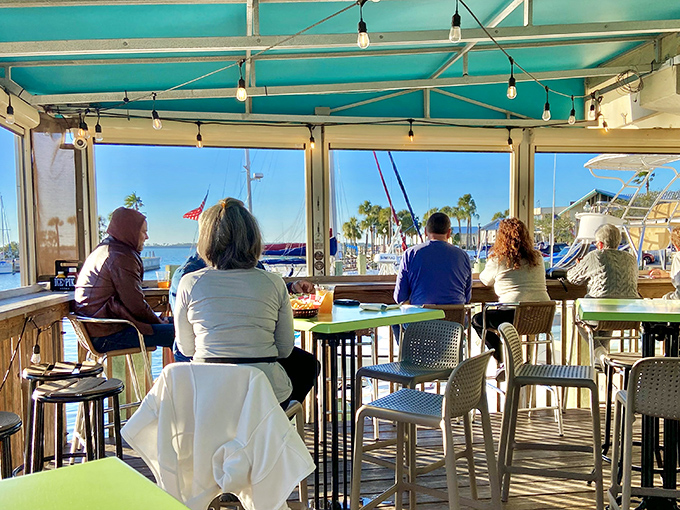 The covered patio offers front-row seats to marina life, where fellow diners become temporary neighbors in this floating community of food lovers.
