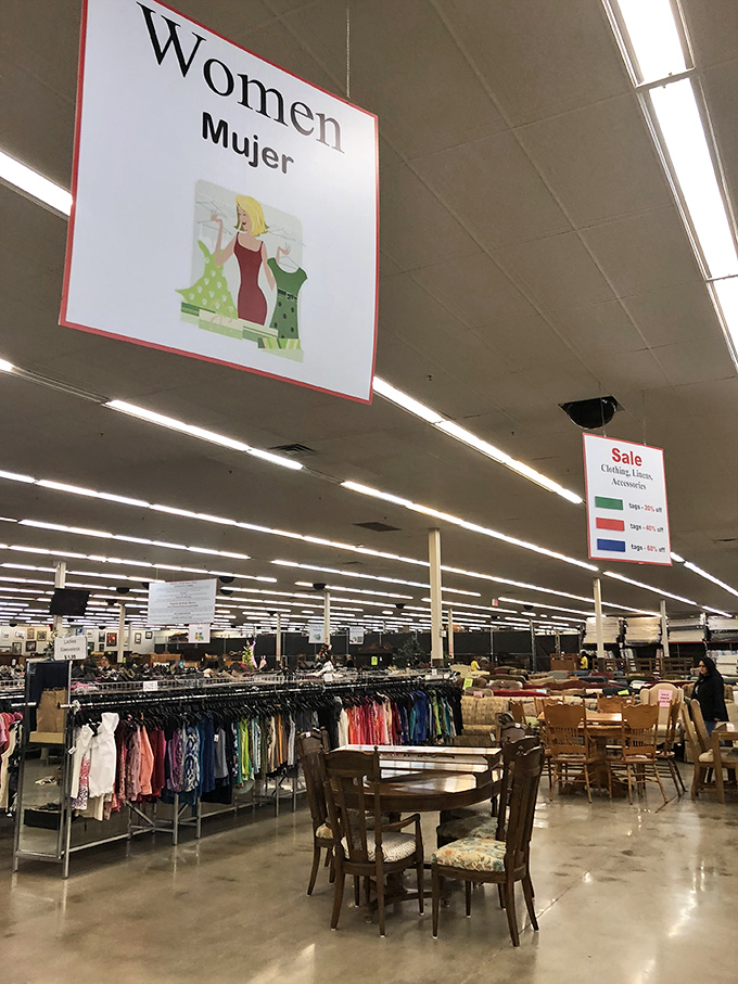 The women's clothing section spans generations of style. Under these bright signs, vintage treasures and contemporary finds hang side by side.
