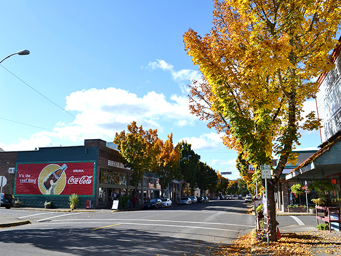 Golden autumn leaves frame your stroll through historic Cottage Grove, where a classic Coca-Cola mural adds a nostalgic local touch.