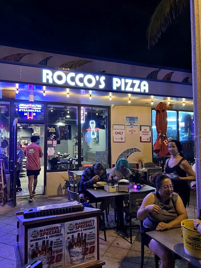 Beachfront pizza with string lights overhead—because calories don't count when you're living your best vacation life.