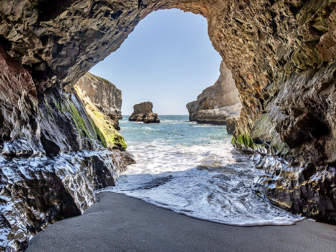 Shark Fin Cove frames its wild beauty like a secret passageway&mdash;nature&rsquo;s monument rising just beyond the shadows.