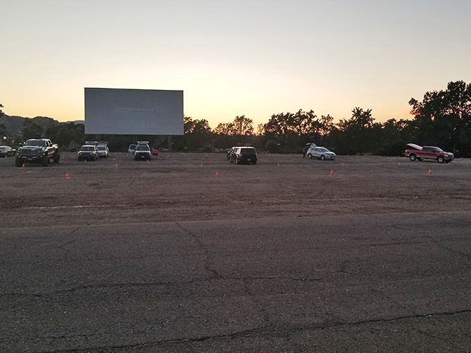 Nature's amphitheater at Lakeport Auto Movies, where orange markers guide vehicles across this dusty lot toward celluloid dreams and starlit stories.